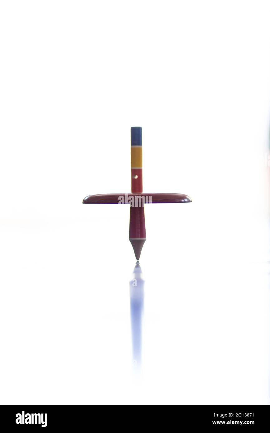 Colorful wooden peg-top or a teetotum isolated on a white background ...