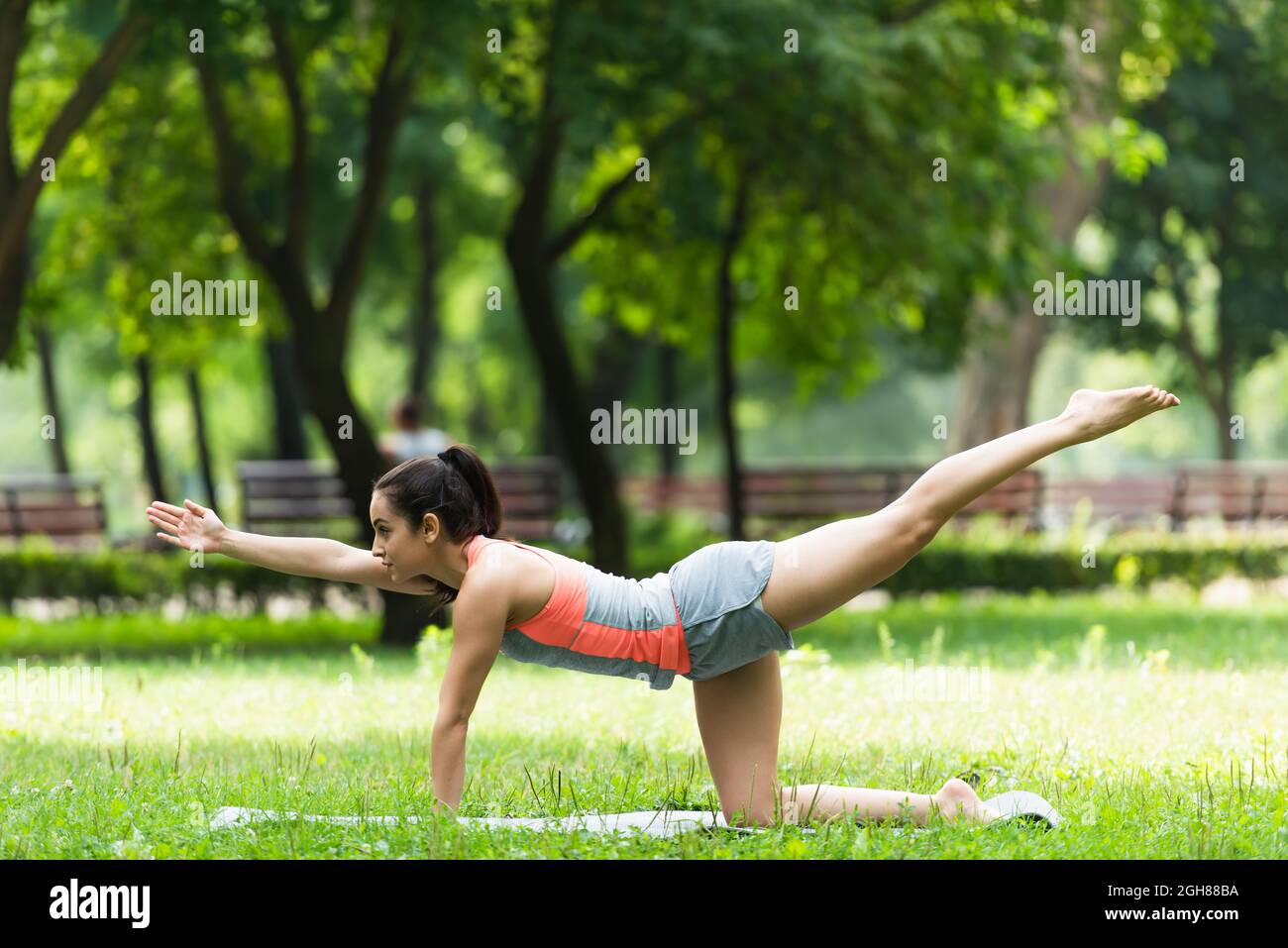 side view of young woman practicing balancing table pose on yoga mat ...