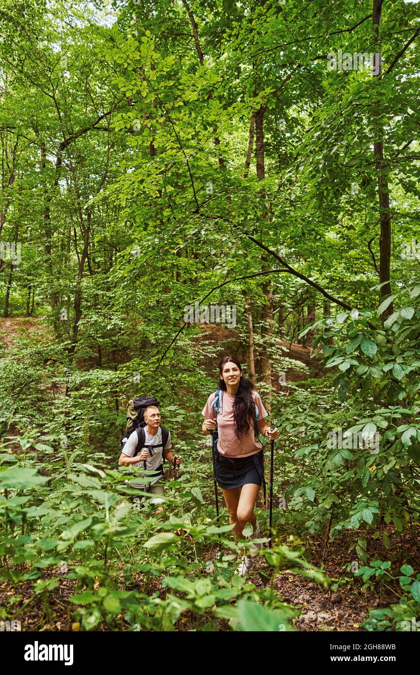 Happy young couple going climbing in forest Stock Photo - Alamy