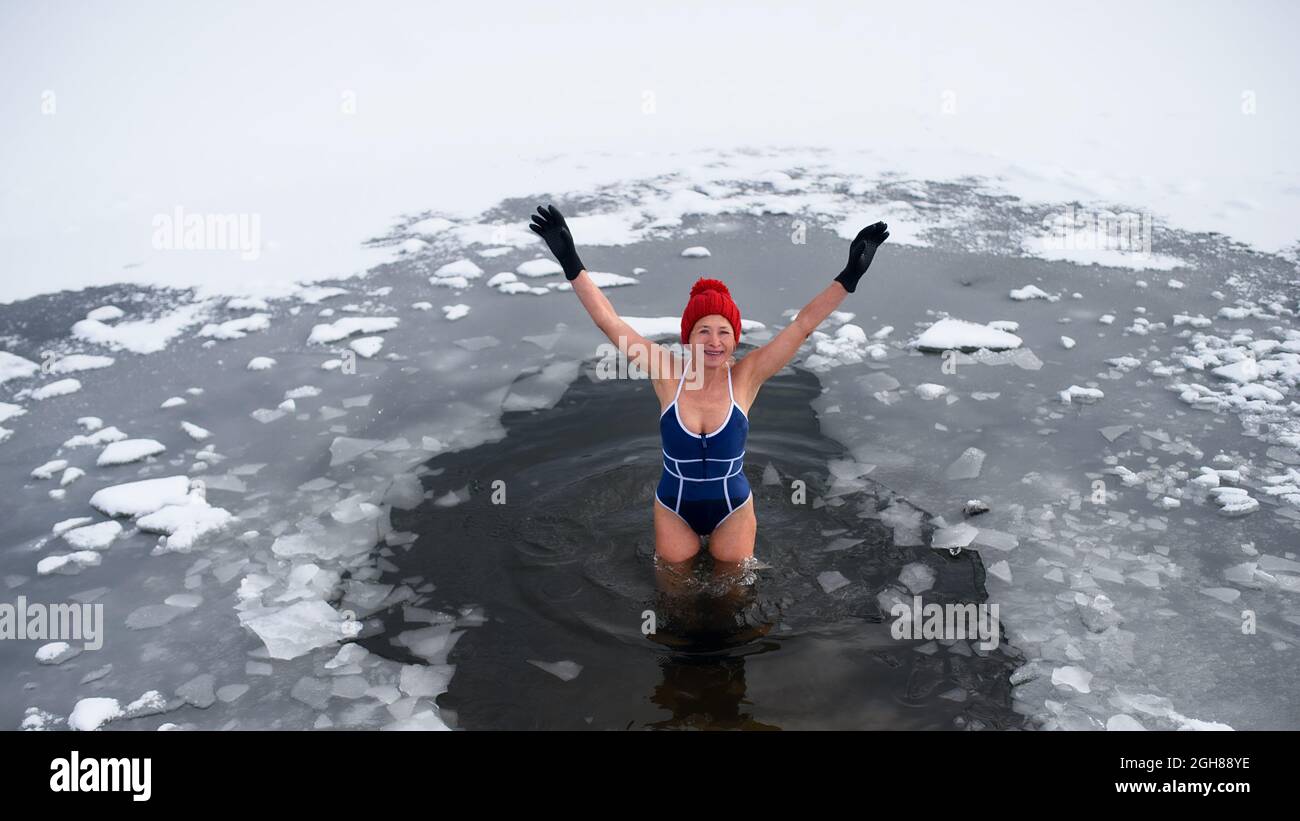 High-angle view of active senior woman in swimsuit outdoors in winter ...