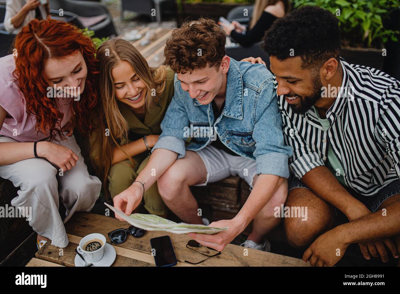 Top view of group of happy young people sitting in outdoors cafe on ...