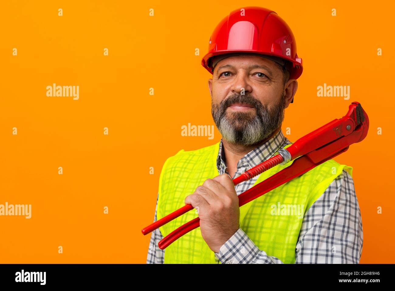 Portrait of senior construction worker in yellow vest in studio Stock ...