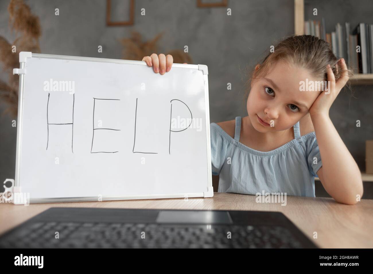 a sad girl sits at a computer laptop, suffering from cyberbullying and ...