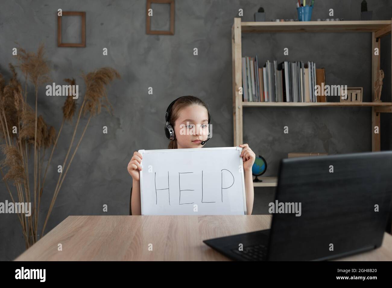 a sad girl sits at a computer laptop, suffering from cyberbullying and ...