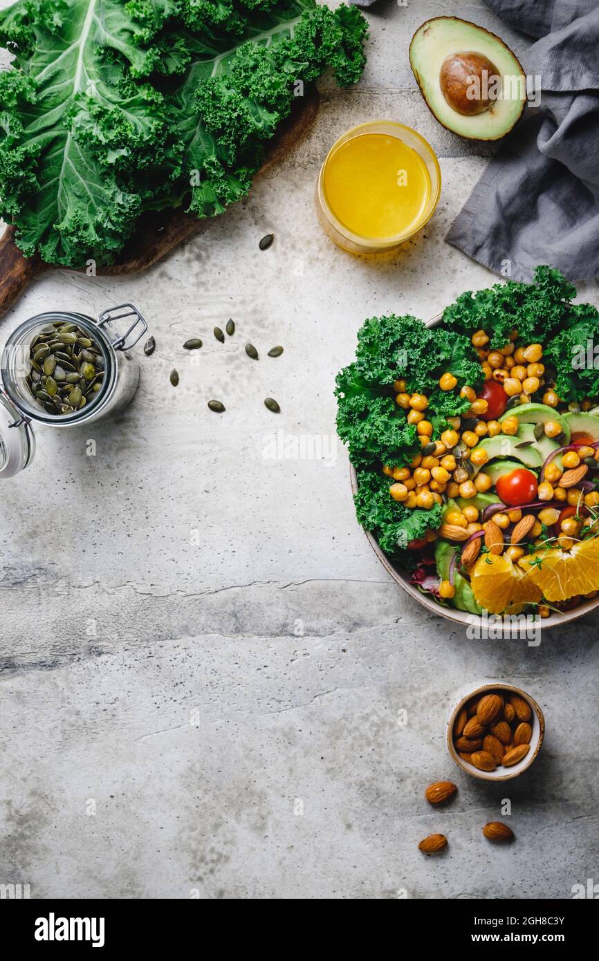 Food frame background with salad, greens and seeds on a grey table ...