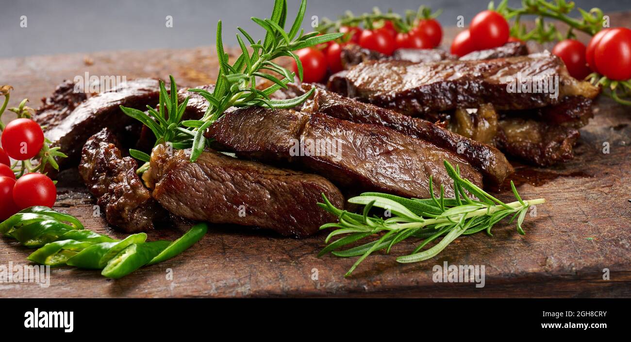 roasted piece of beef ribeye cut into pieces on a vintage brown ...