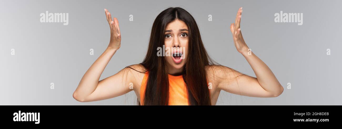 shocked woman with long hair gesturing isolated on grey, banner Stock ...