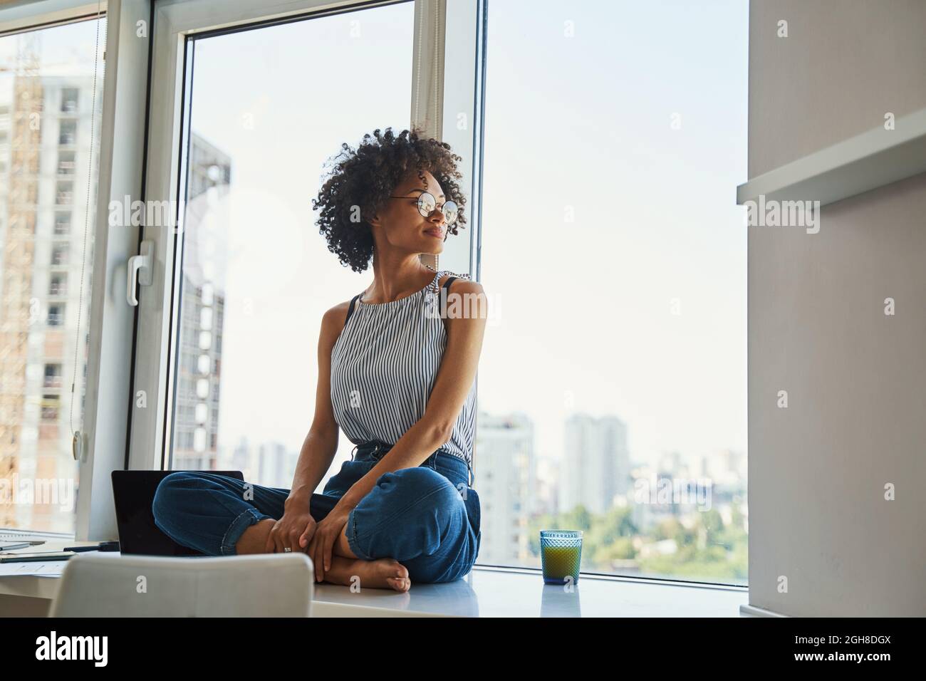 Cute tranquil woman leaned back against the window looking away Stock ...