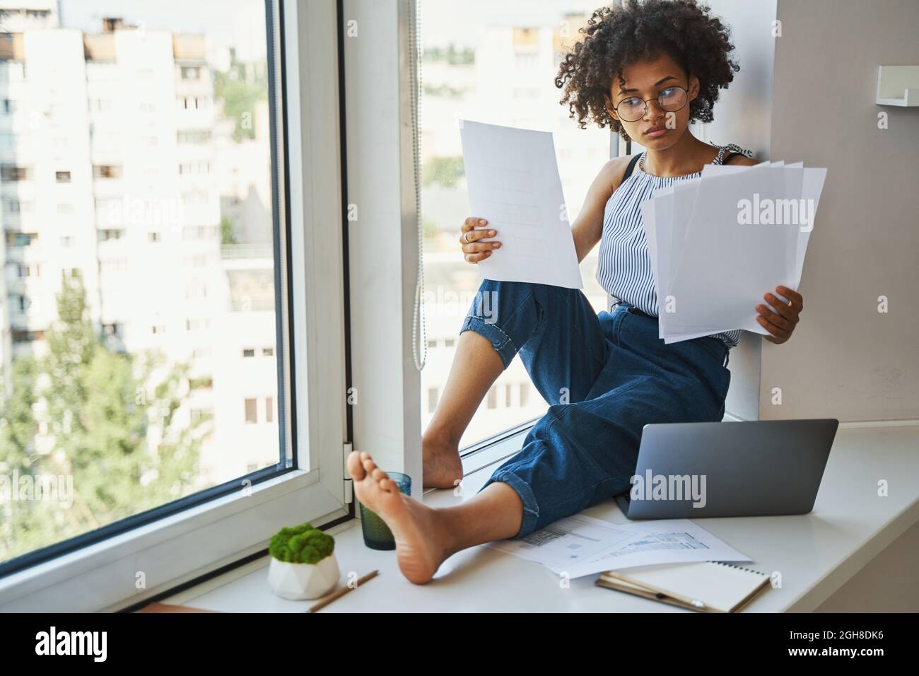 Concentrated young lady architect scrutinizing technical drawings Stock ...