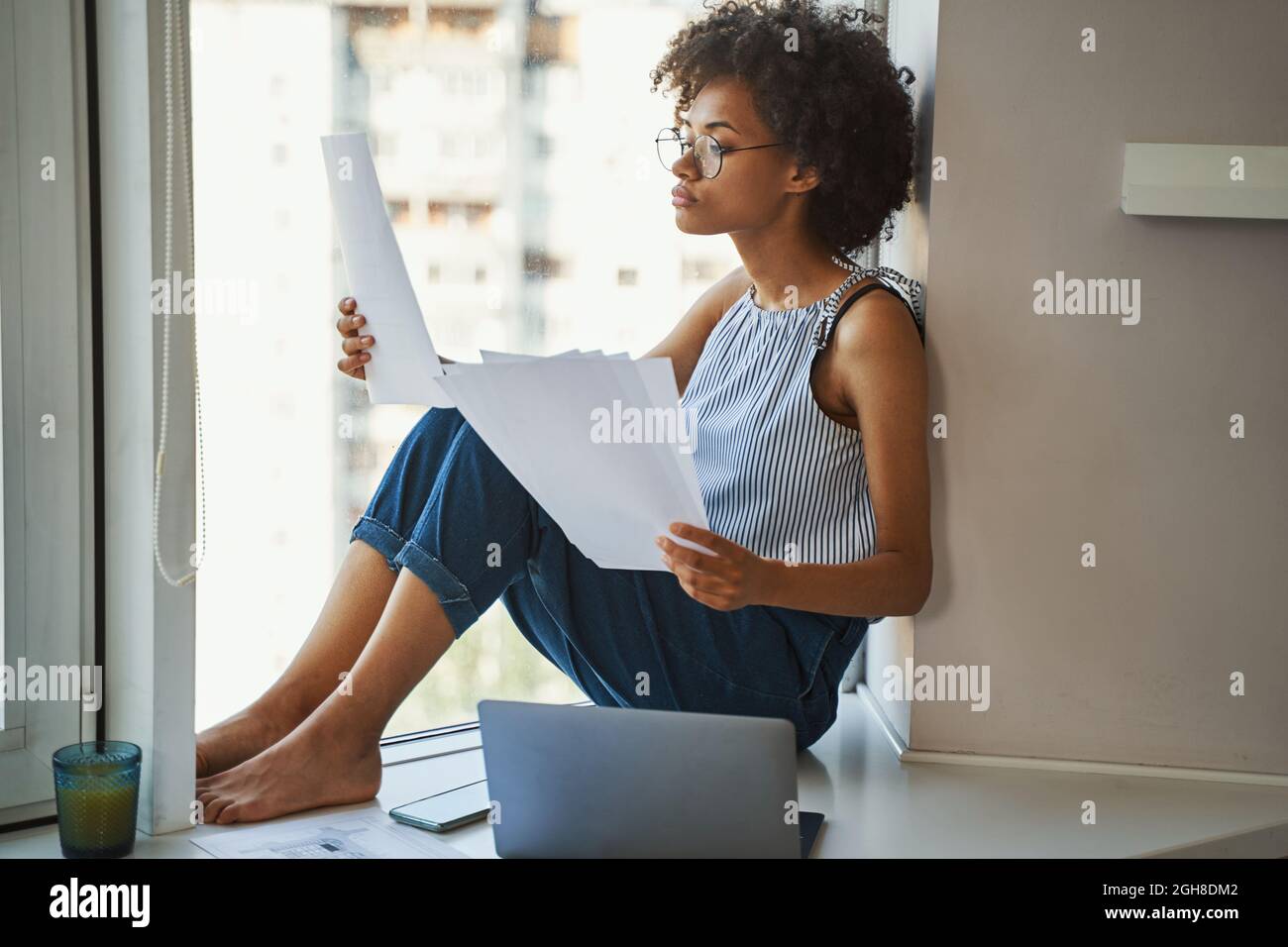 Young cute draftswoman focused on reading technical drawings Stock ...