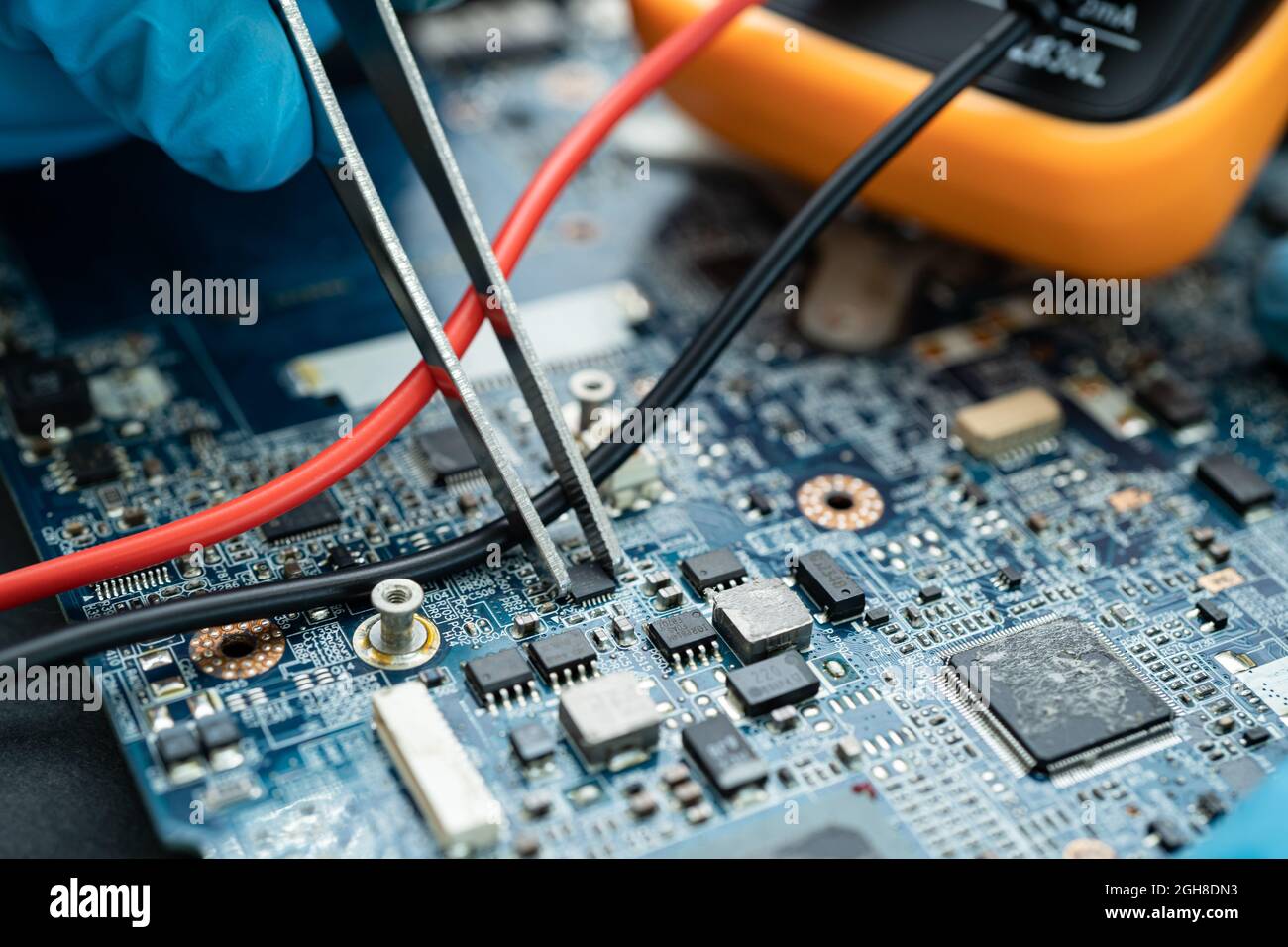 technician repairing inside of hard disk by soldering iron. Integrated ...