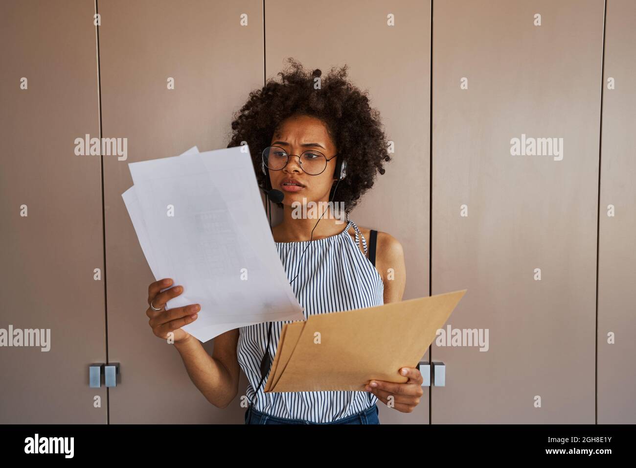 Draftswoman in headphones with a microphone scrutinizing technical ...