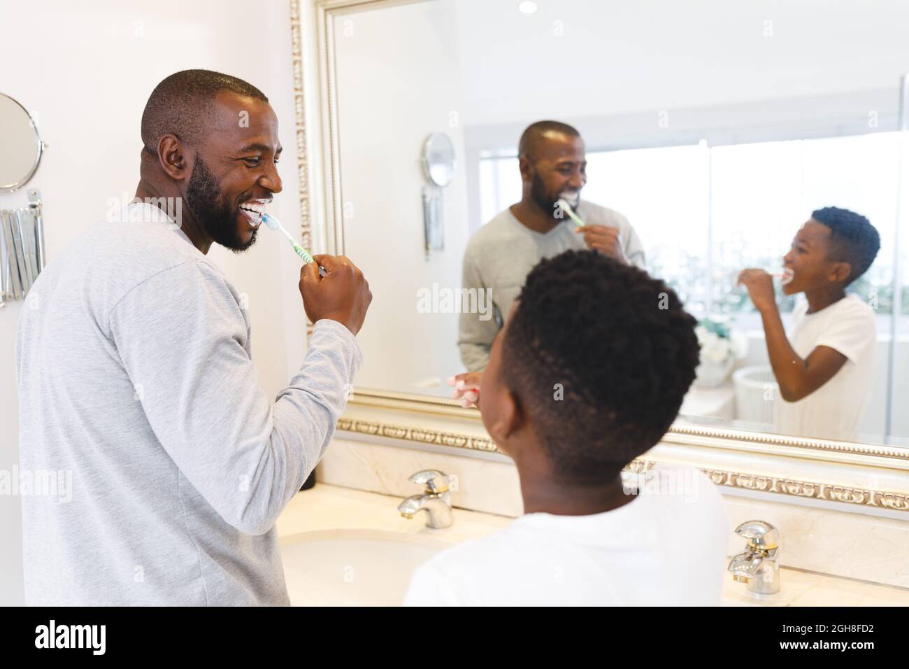 Smiling African American Father And Son Having Fun Brushing Teeth