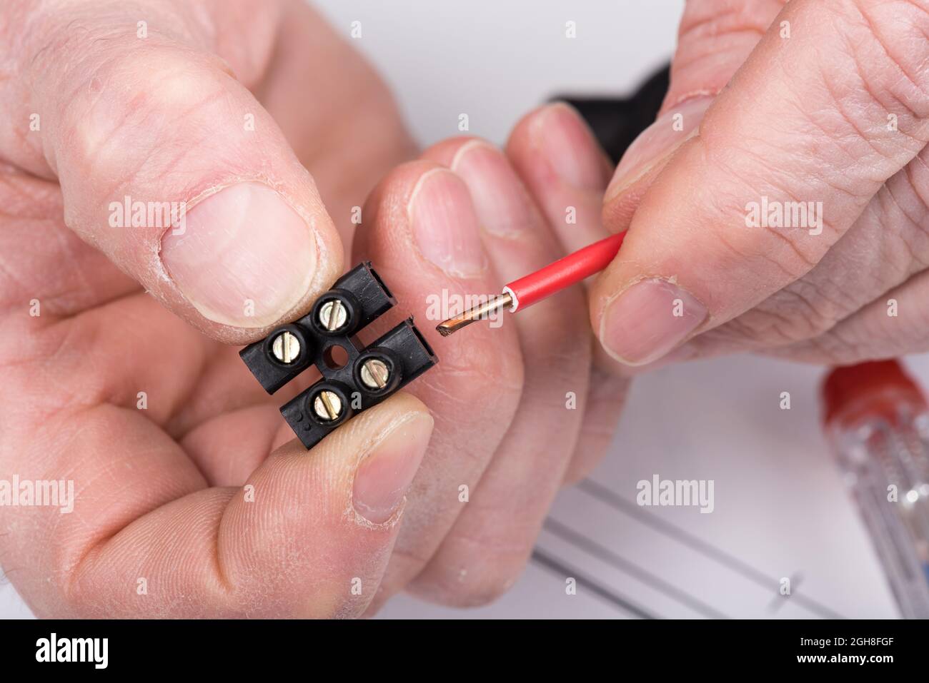 Hand putting a wire in a connector Stock Photo - Alamy