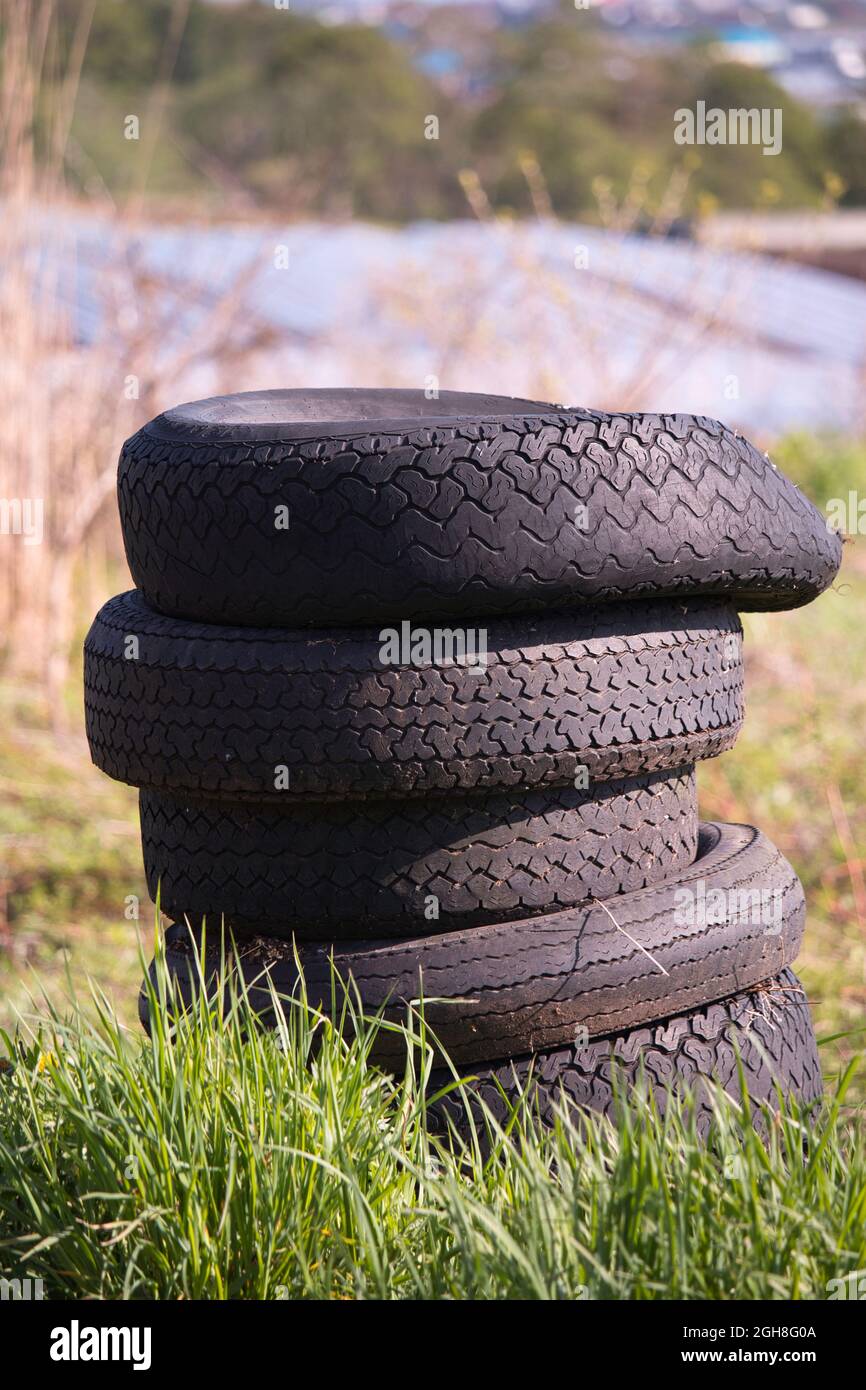 A stack of old used tyres abandoned in the countryside Stock Photo - Alamy