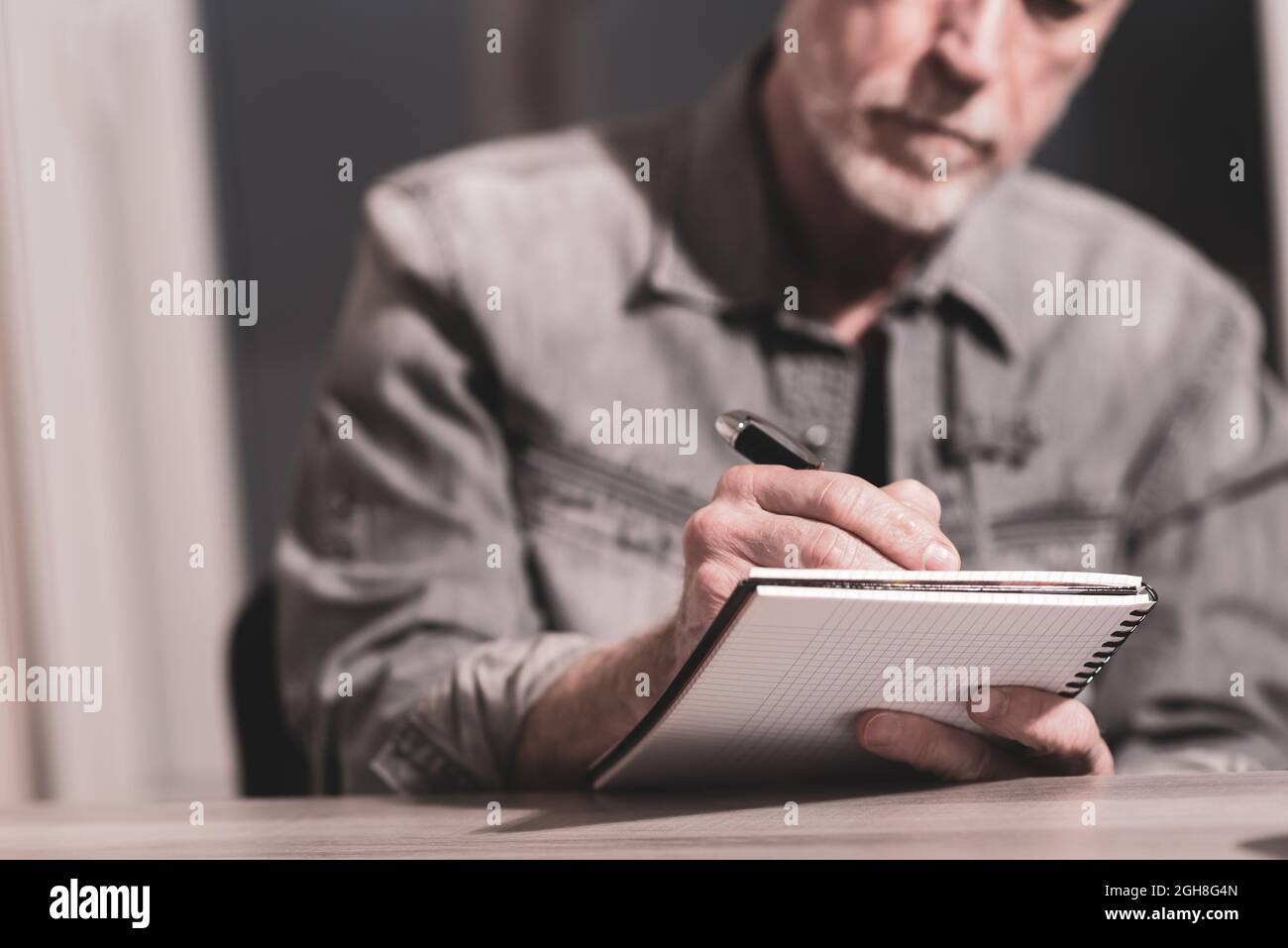 Mature man taking notes on a notebook Stock Photo - Alamy
