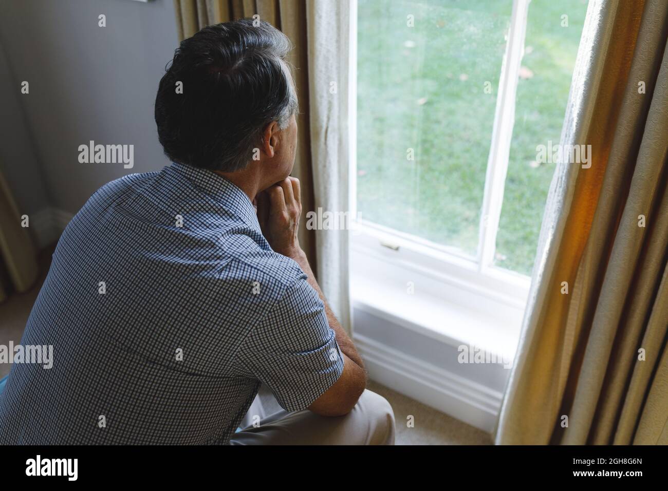 Thoughtful senior caucasian man sitting on sofa and looking through ...