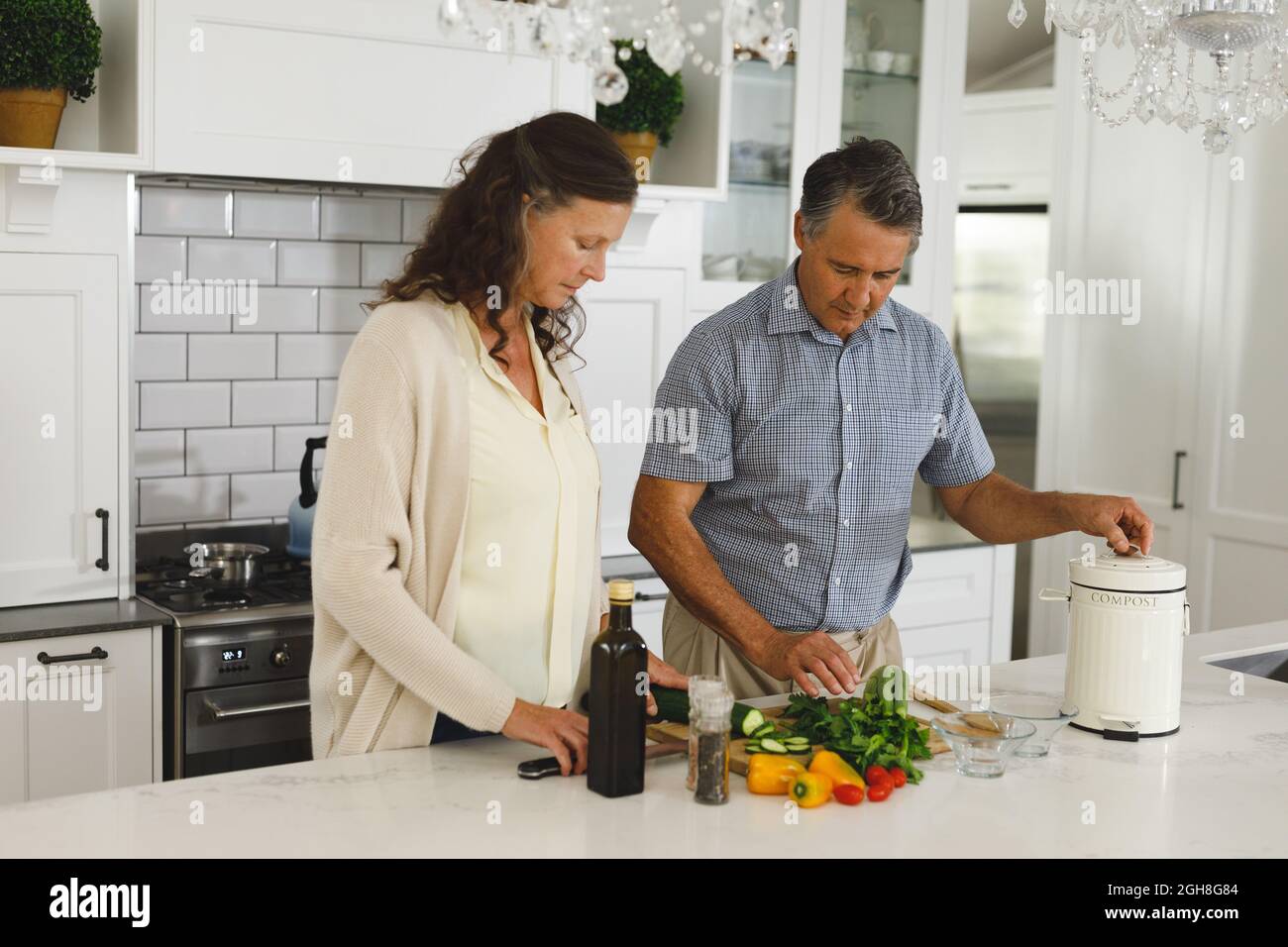 Senior caucasian couple in modern kitchen, cooking together composting ...