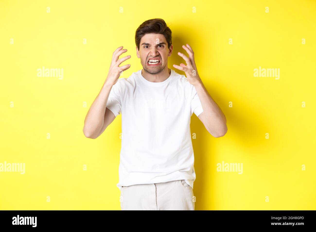 Angry man looking mad, grimacing and shaking hands furious, standing ...