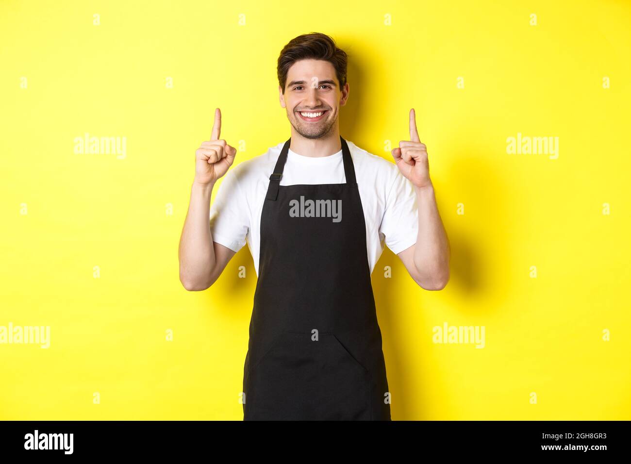 Handsome barista showing advertisement, coffee shop promo offer ...