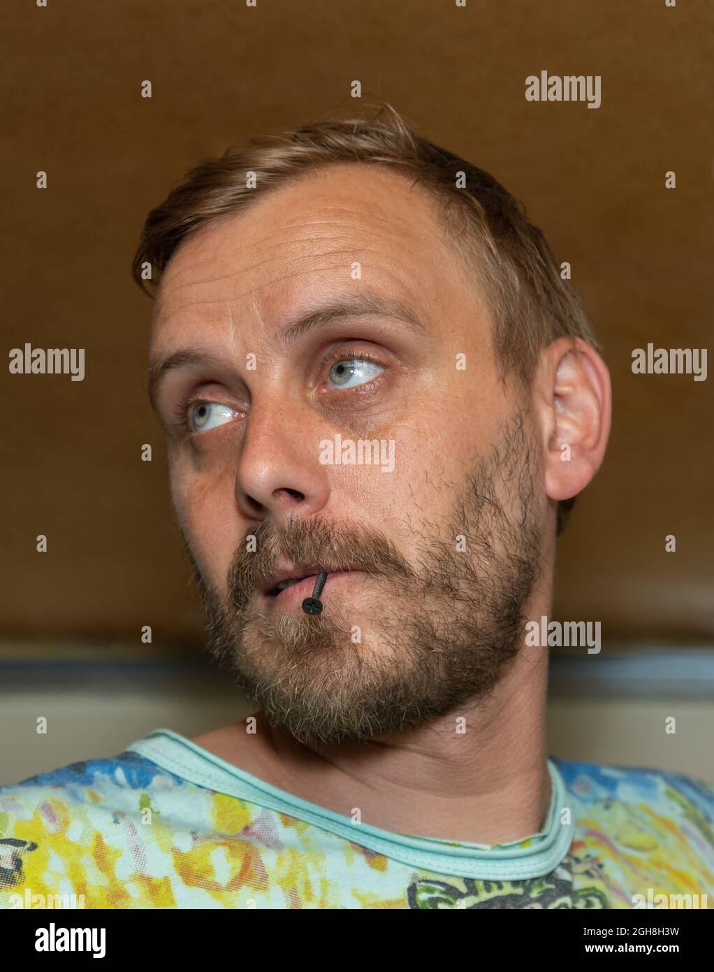 Adult man with screw in a mouth Stock Photo - Alamy
