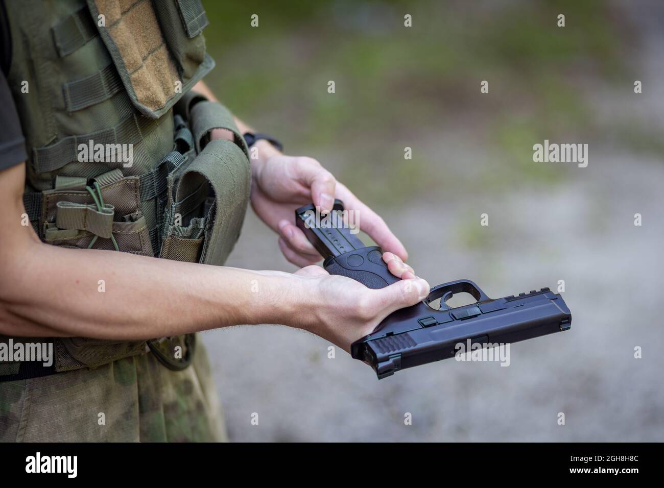 Close up of a man reloading an airsoft pistol Stock Photo - Alamy