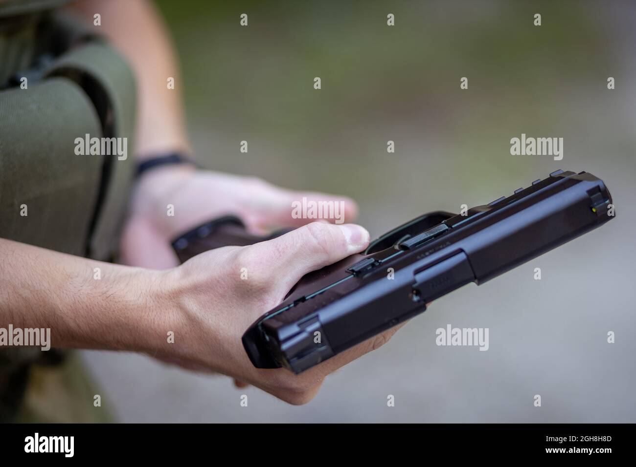 Close up of a man reloading an airsoft pistol Stock Photo - Alamy