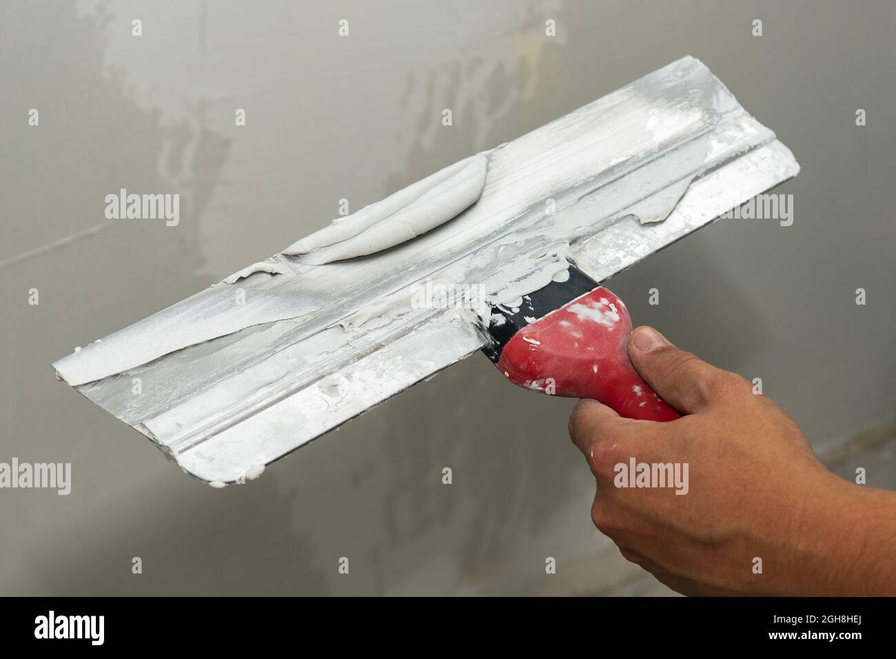 Workman is repairing walls of house Stock Photo - Alamy