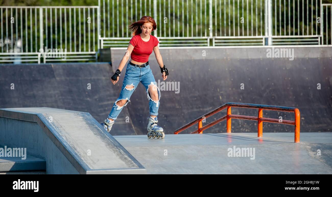 Beautiful girl rollerblading at park ramp. Female teenager with rollers ...