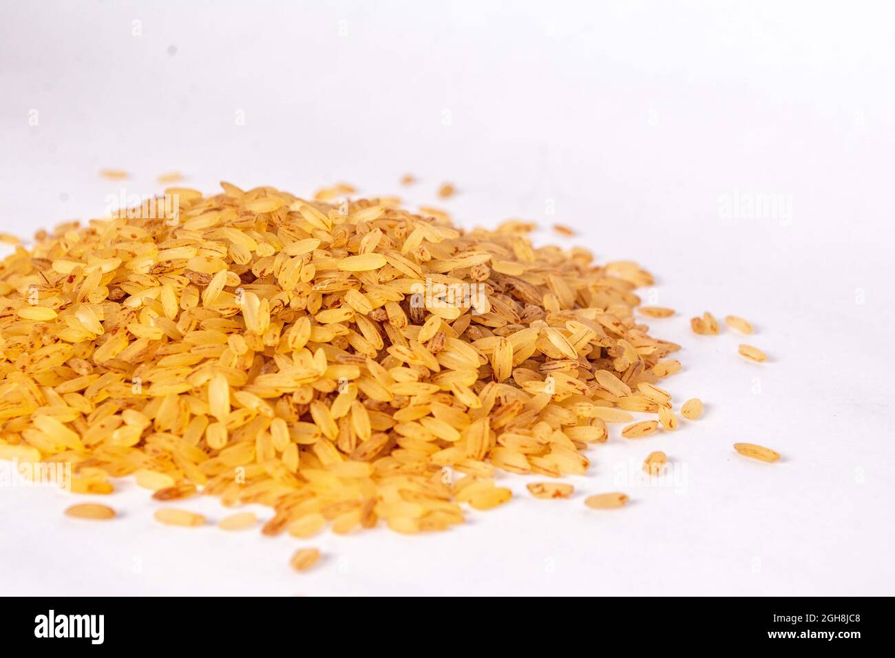 Whole grain brown rice close up - white background Stock Photo - Alamy