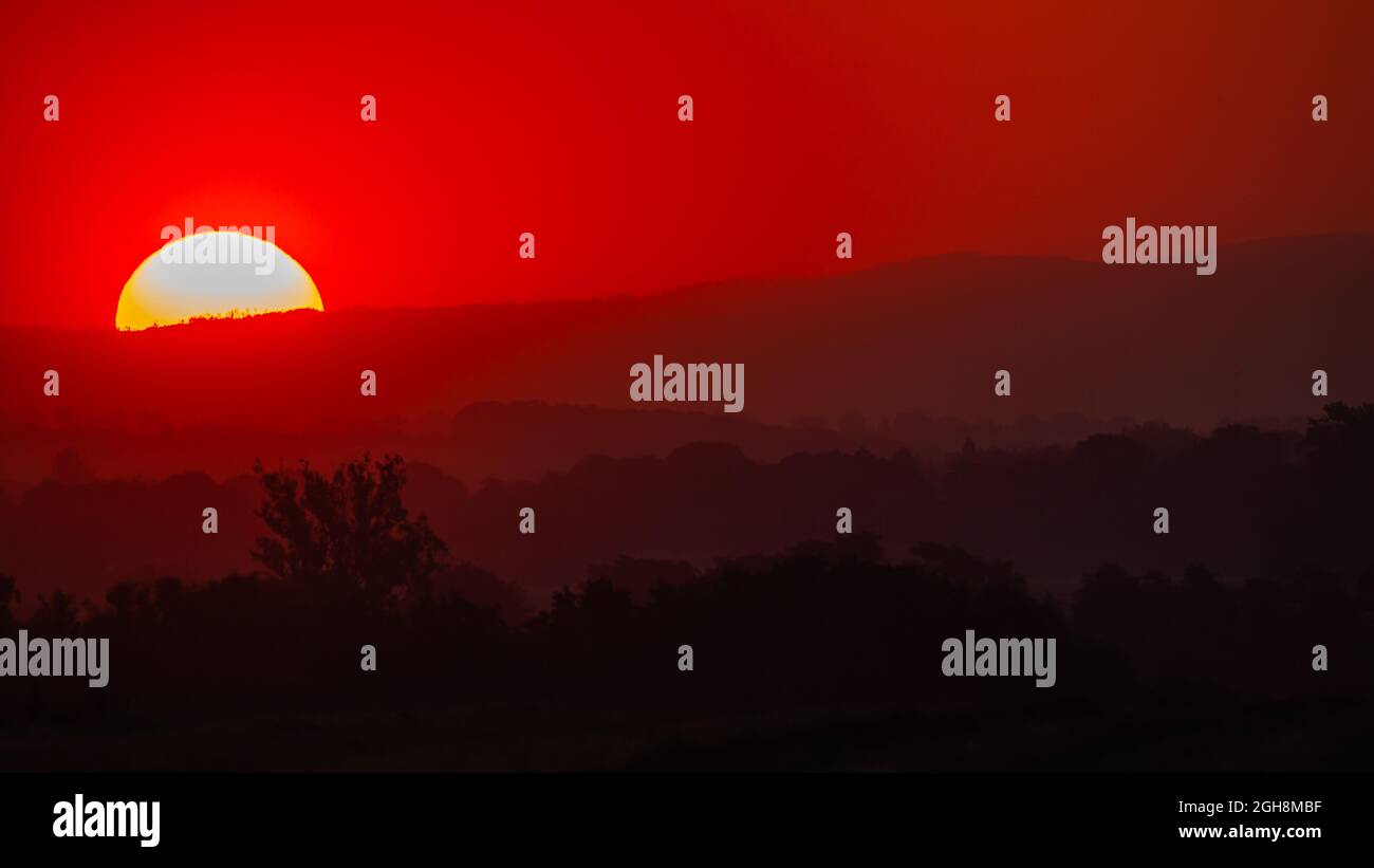 A bloody sunset over the fields. Distant landscape plans visible Stock ...