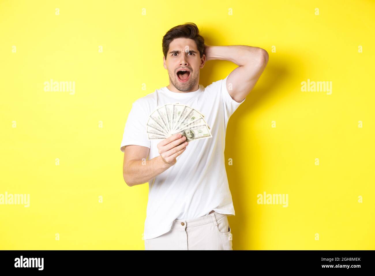 Frustrated man holding money, shouting and panicking, standing over ...