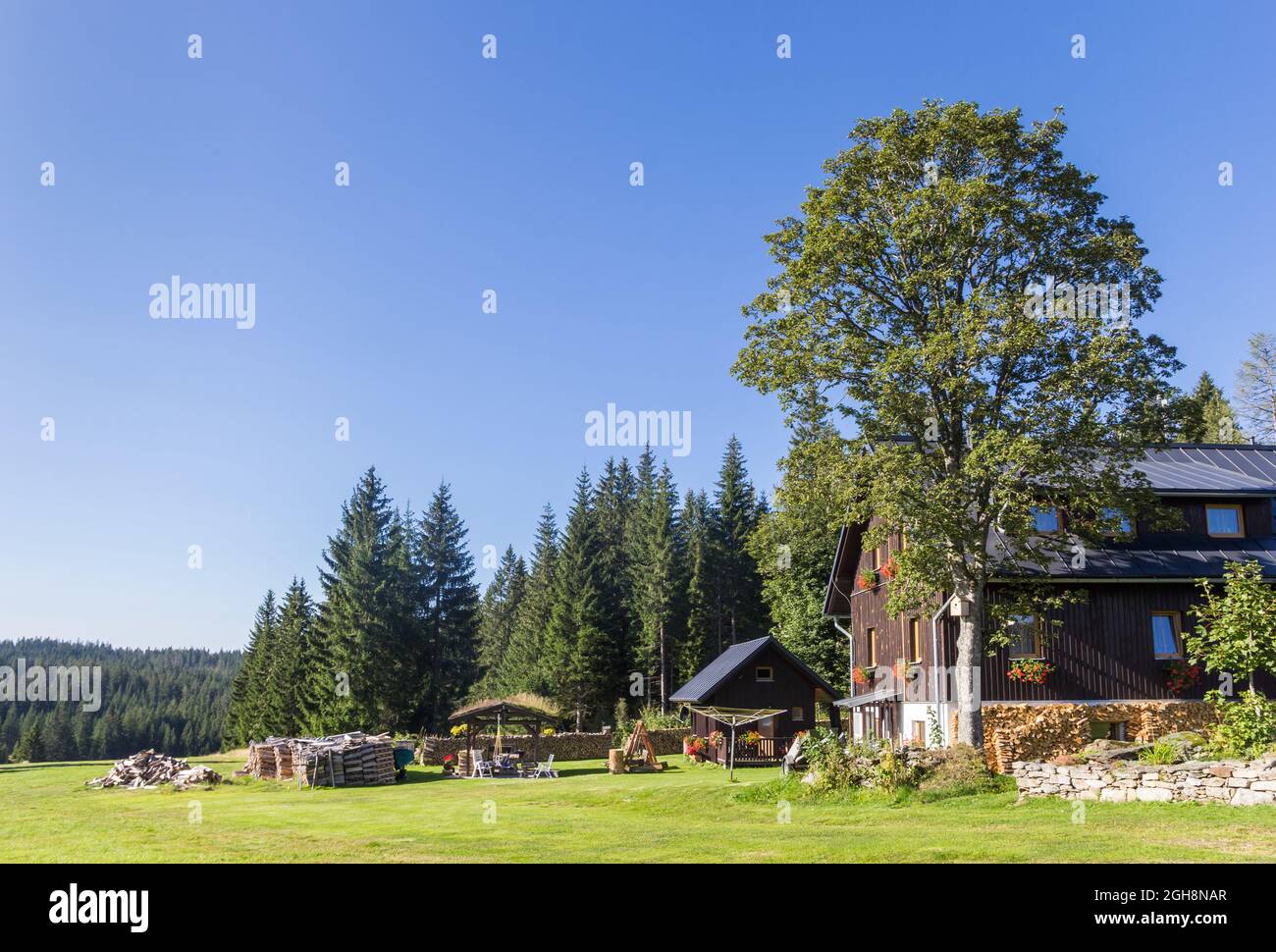 Traditional wooden house in the landscape of the Sumava mountains ...