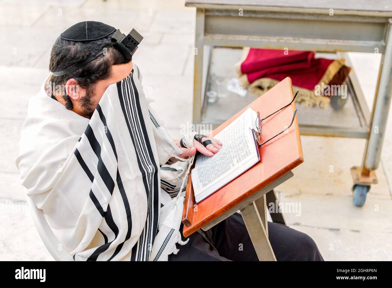 Orthodox Jewish man, with phylacteries and shawl, covering his eyes ...