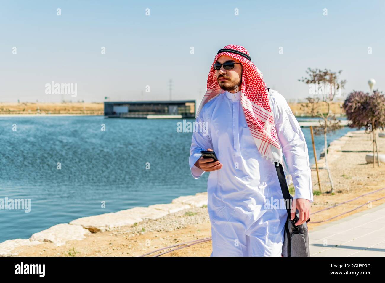 Front view of a Saudi Arabian man, in traditional dress, walking in a ...