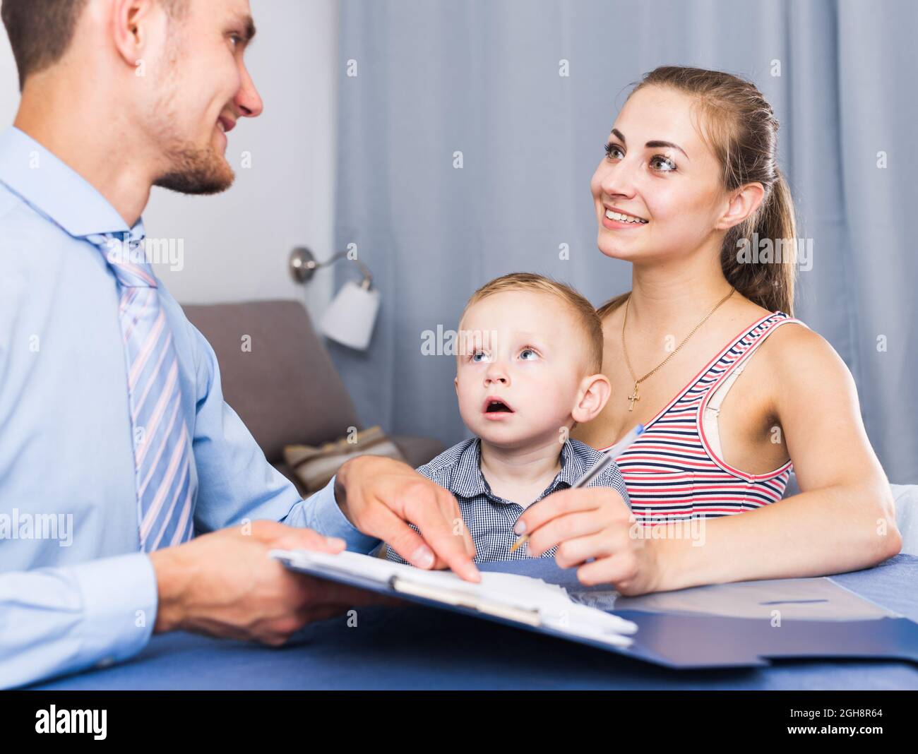 .Smiling female signing documents with worker of research company Stock ...