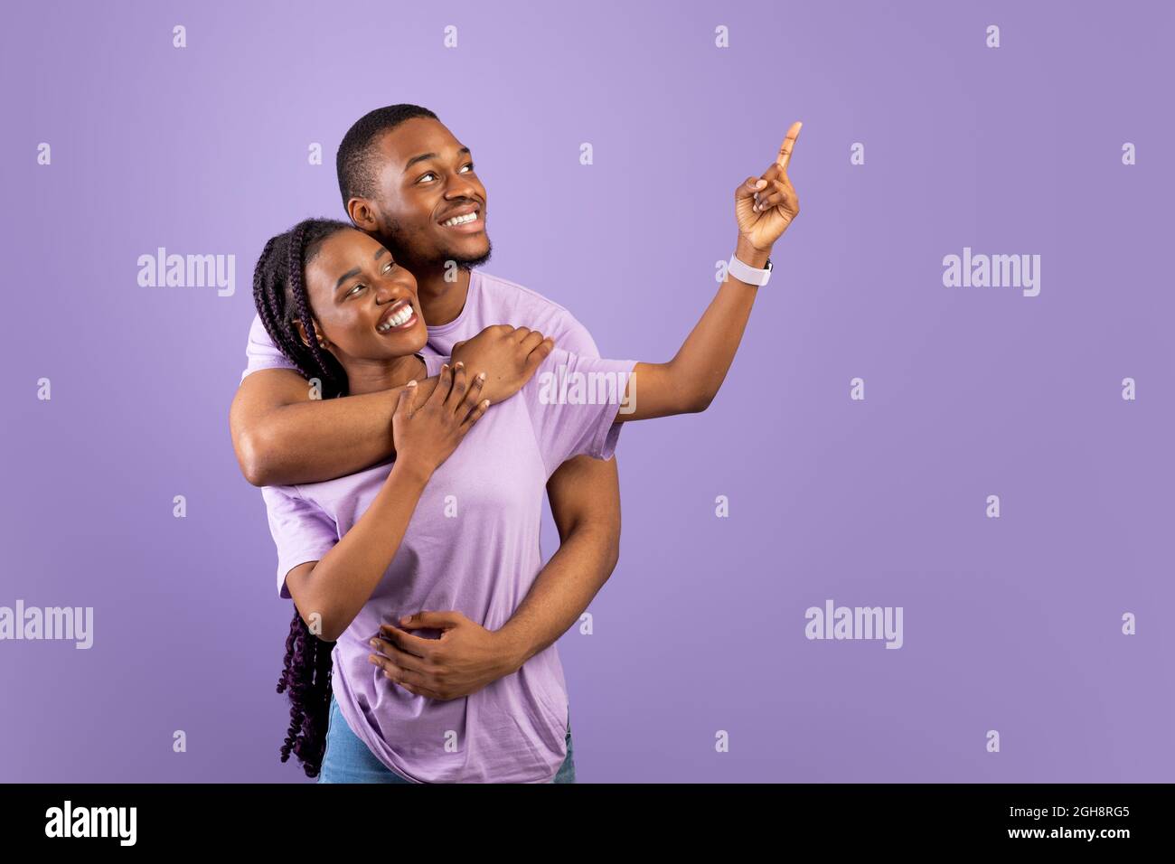 Smiling black couple pointing up at free copy space Stock Photo - Alamy