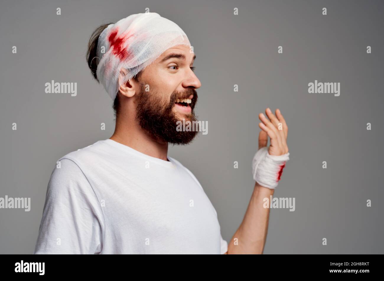 bearded man bandaged head and hand blood light background Stock Photo ...