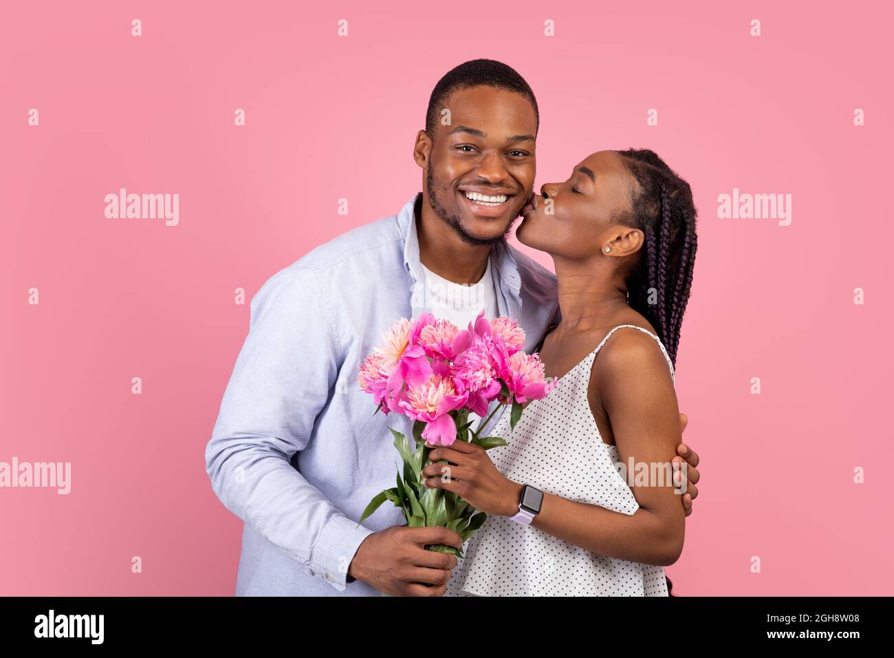 Happy black man making surprise for woman giving flowers Stock Photo ...
