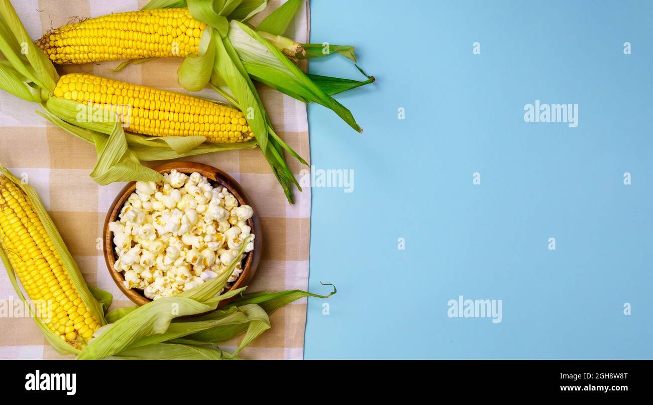 Fresh uncooked corncob, popcorn. Healthy summer food concept. Blue ...