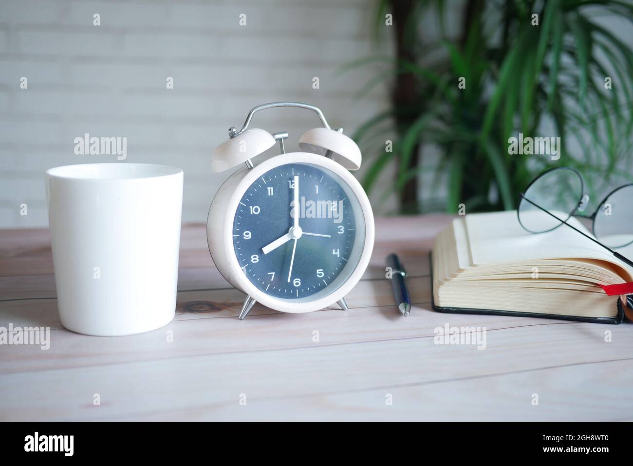 coffee mug, and clock on table close up Stock Photo - Alamy