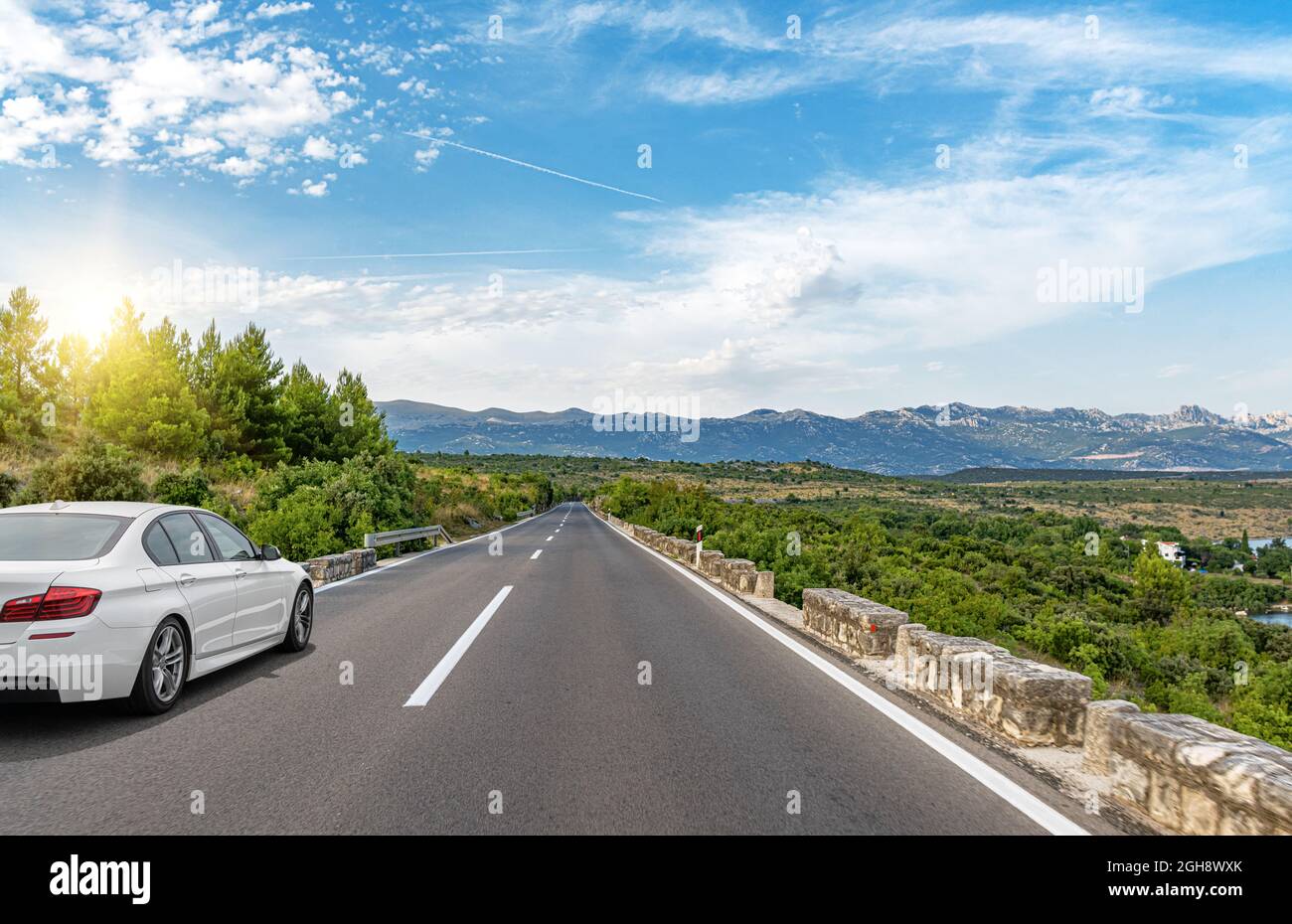 Car is driving along the road. White car on a suburban highway Stock ...