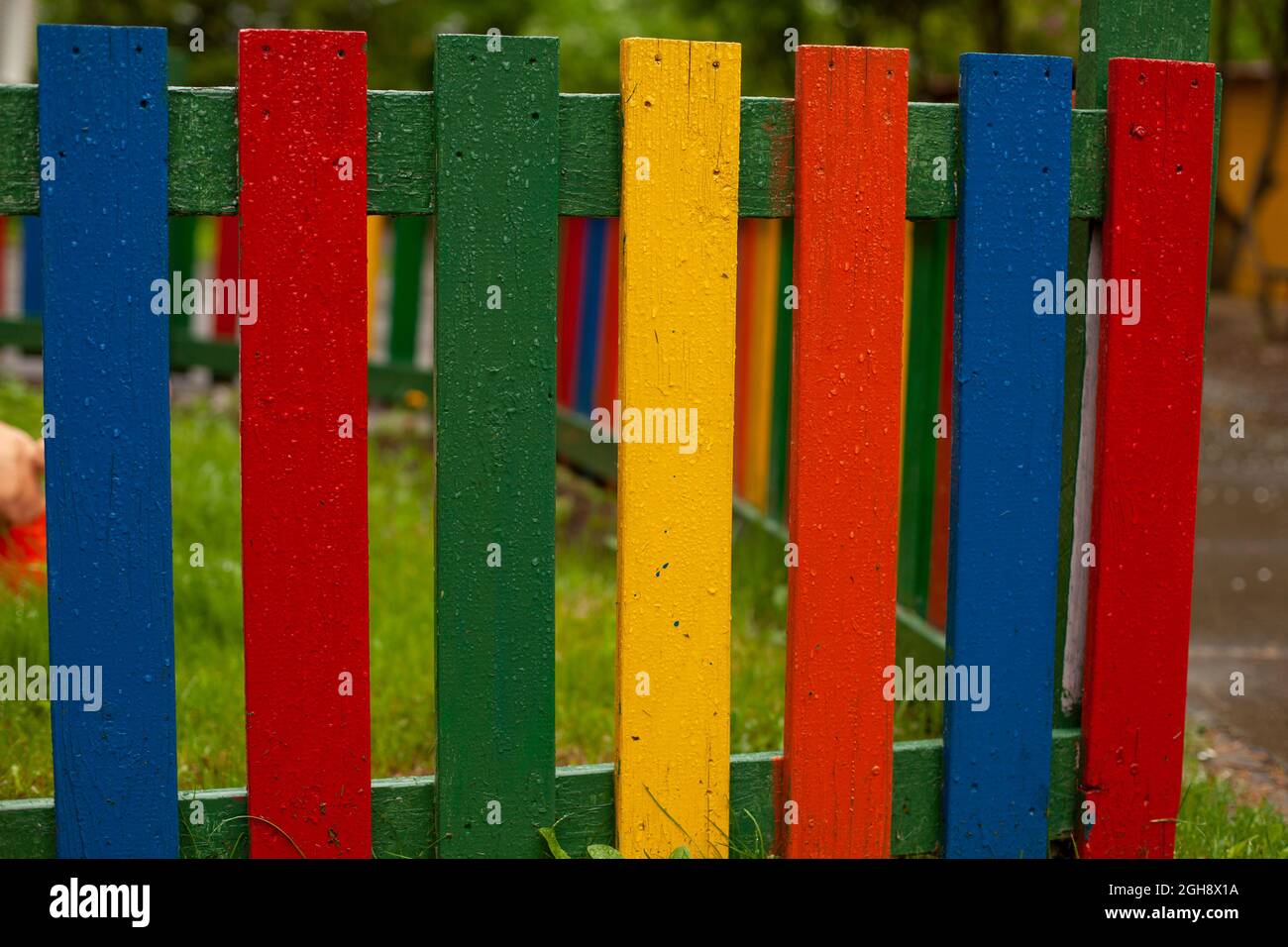 Colored wooden fence made of boards. The fence is painted in different ...