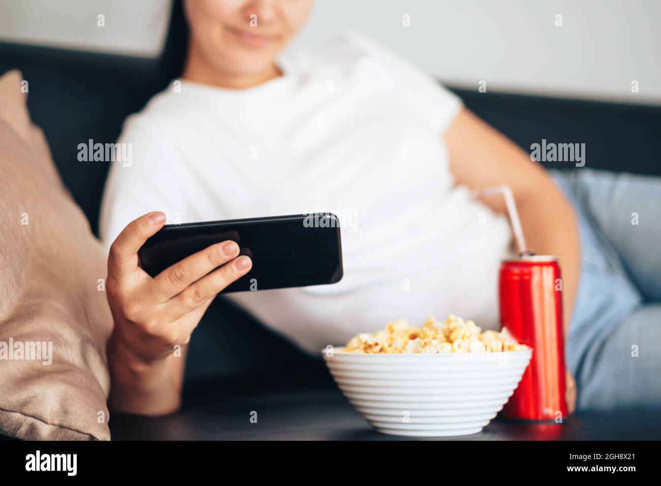 Girl watching eSports live stream with can of juice and popcorn Stock ...