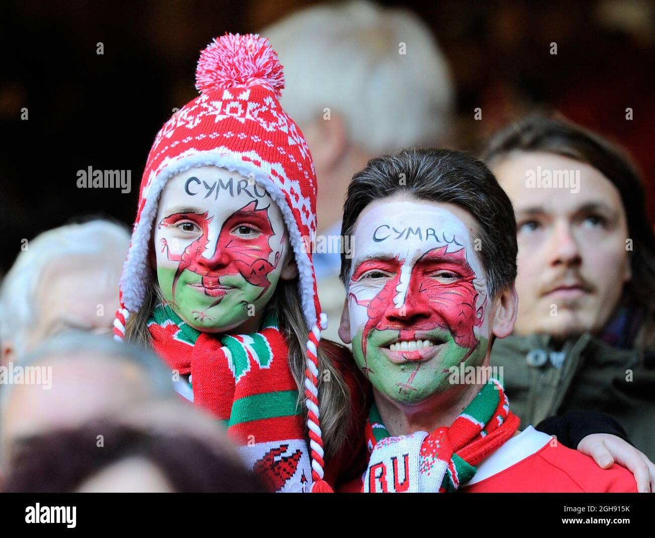Daughter and father with faces painted as the Welsh flag are seen ...