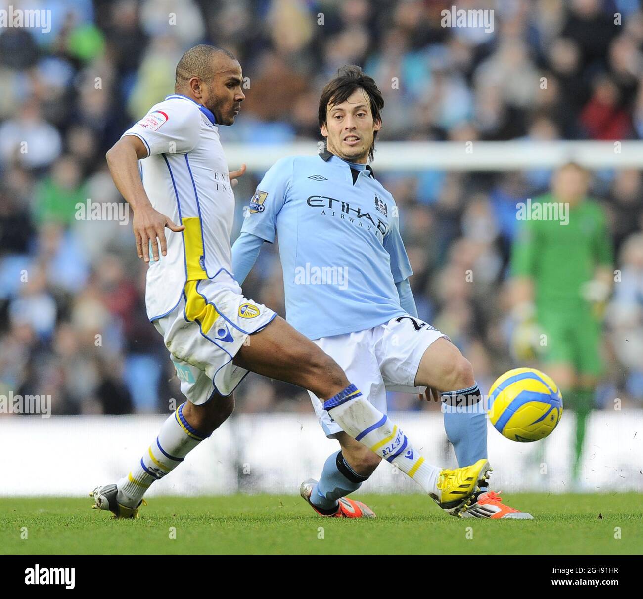 David Silva of Manchester City passes around Rodolph Austin of Leeds ...