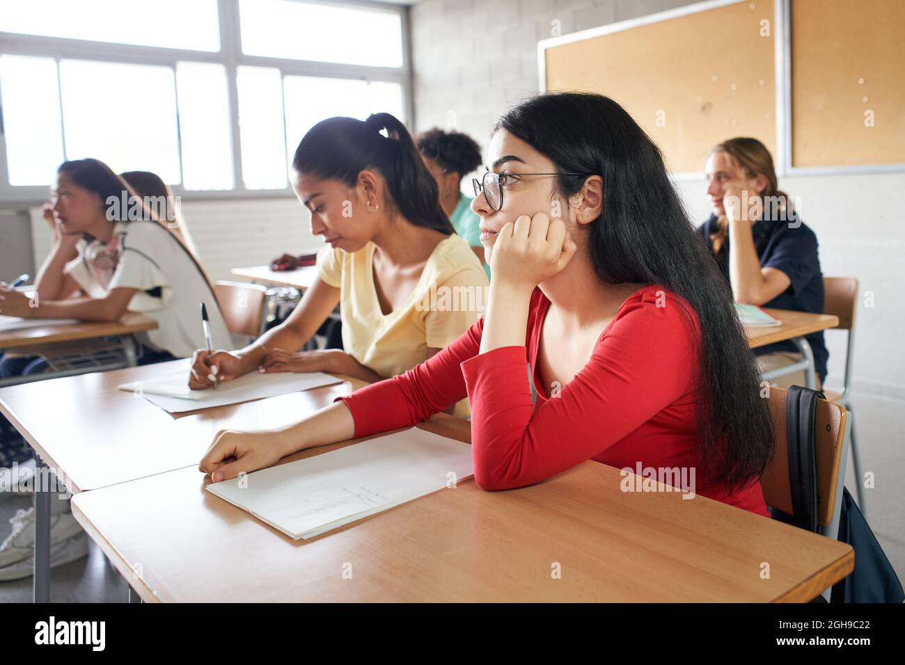 Group of students sitting in class attending to the teacher Stock Photo ...