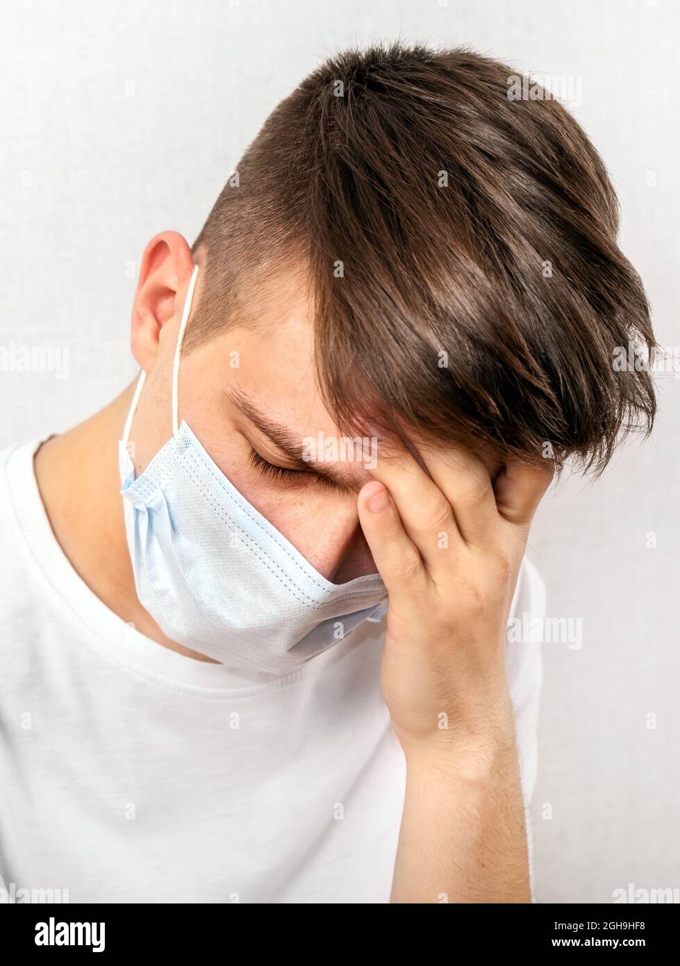 Portrait of Sad Young Man in a Flu Mask by the Wall in the Room Stock ...