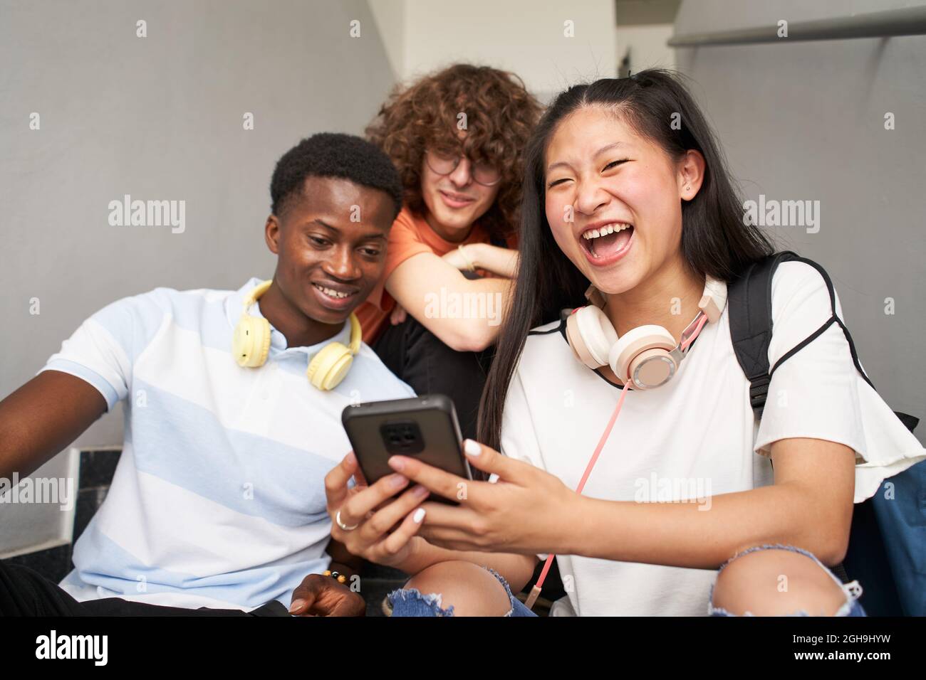 Group of adolescent students of different ethnicities using cell phones ...