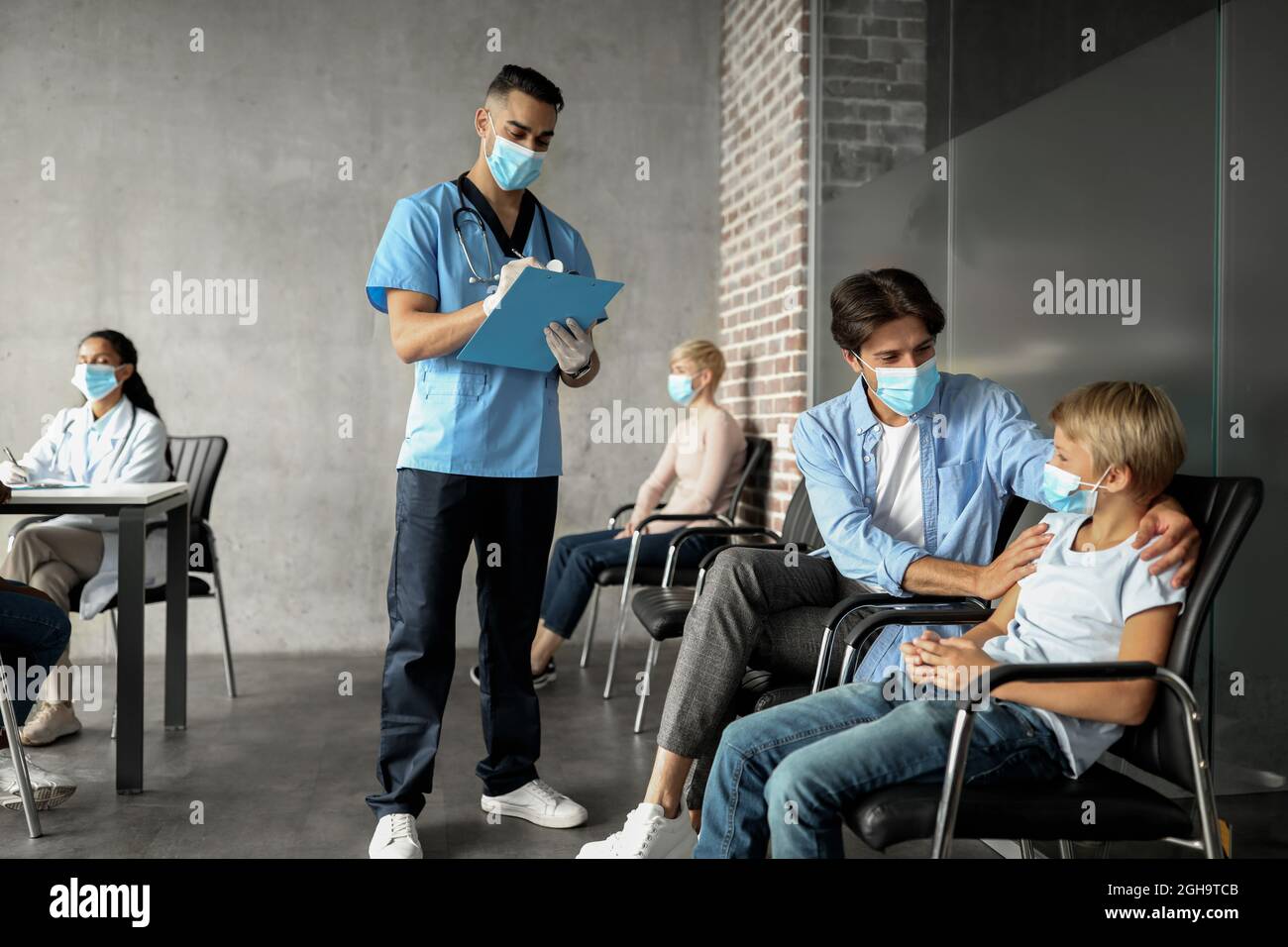 Friendly doctor talking to little boy and father answering question ...
